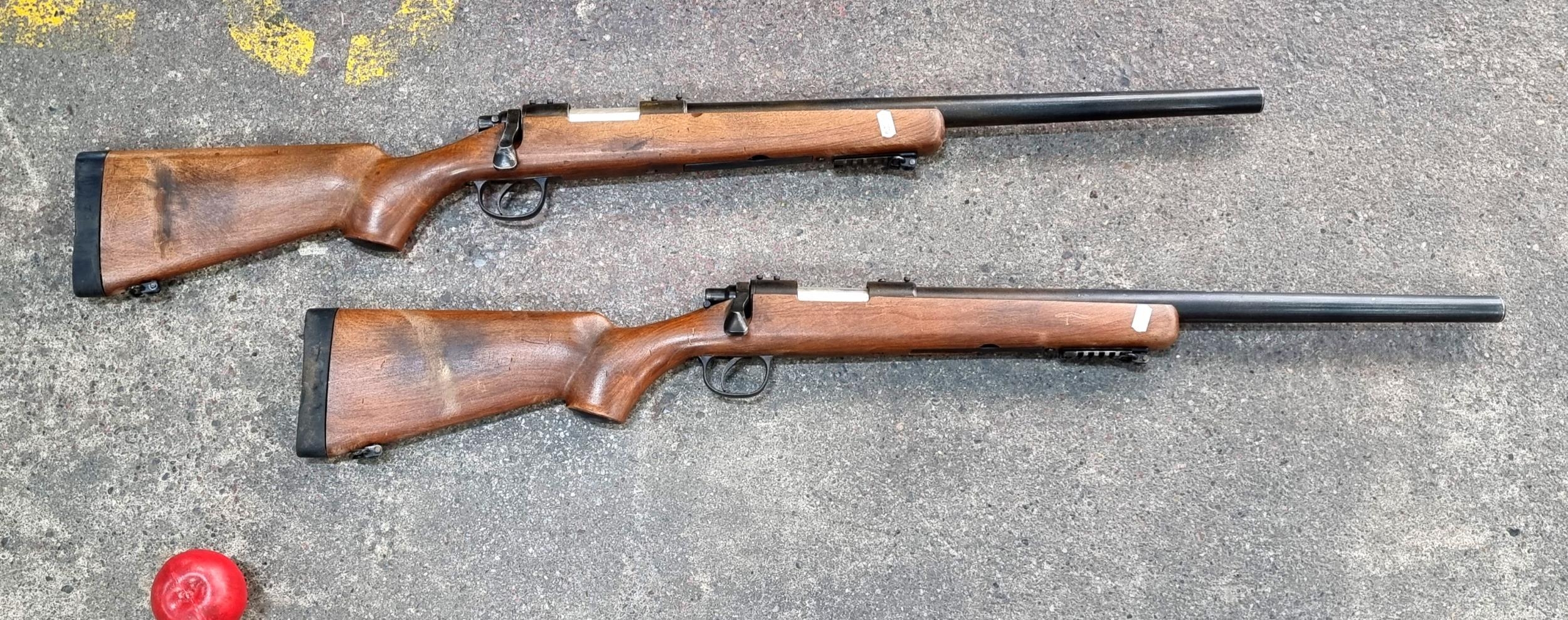 A pair of heavy model bolt action replica rifles. Crafted with a carved ...