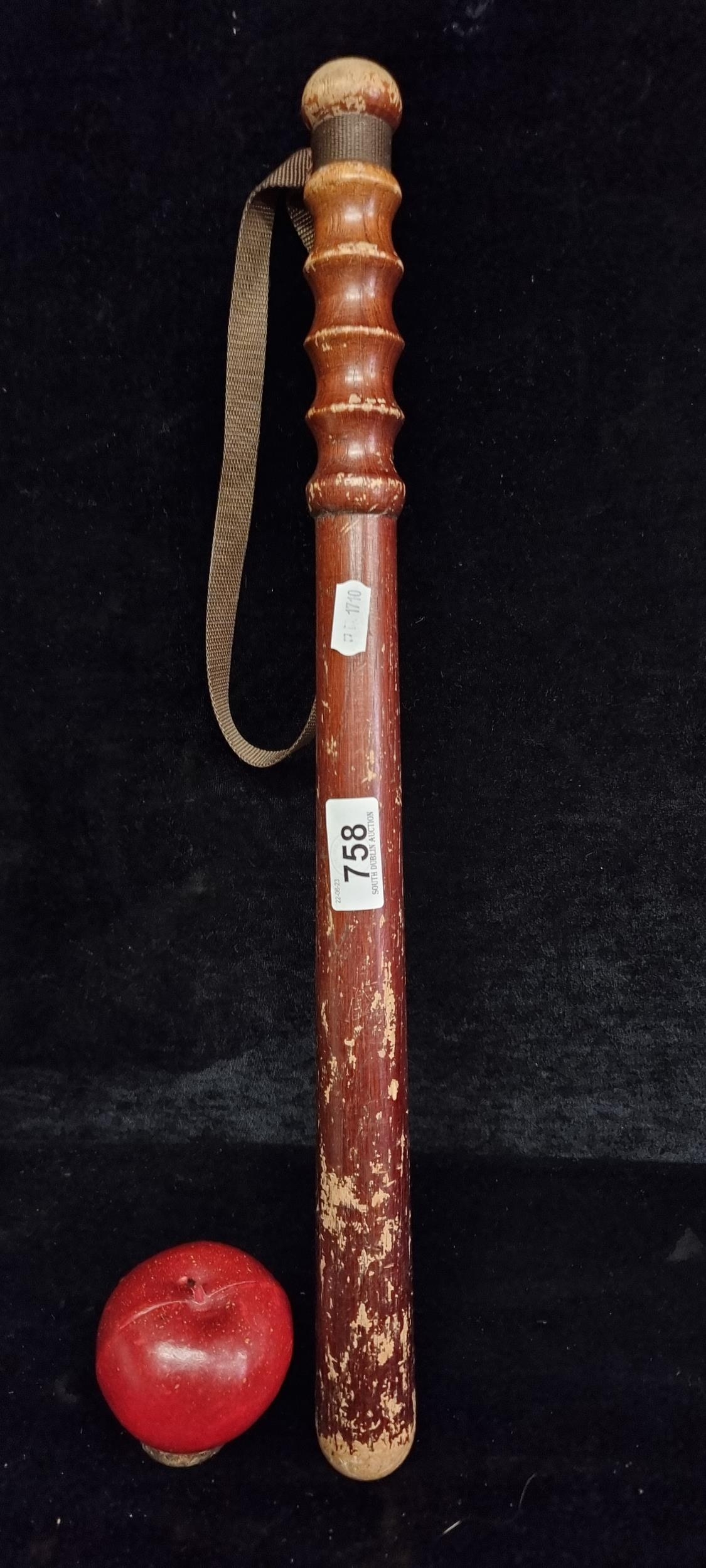 A vintage police wooden baton with lovely patina and a fabric strap.