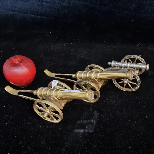 Three heavy model cannons, two larger examples in a brass toned finish ...