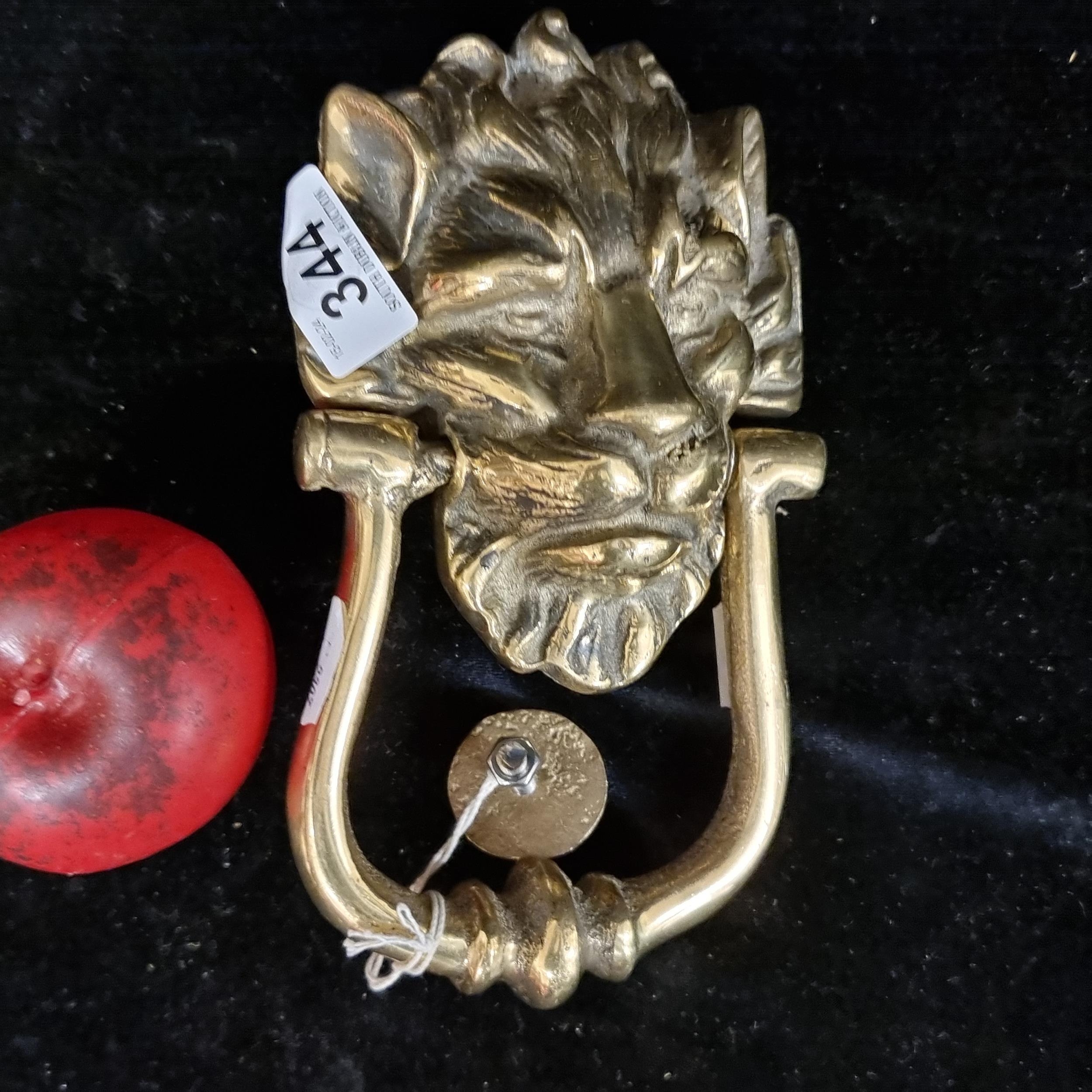 A super large cast brass lions head door knocker.
