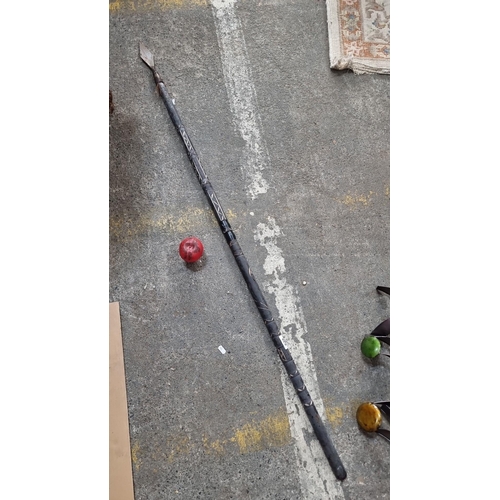 Decorative long tribal spear with carved wooden shaft and iron blade ...