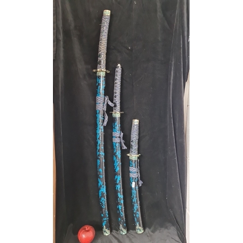 Set of three Japanese-style swords with matching black and blue ...