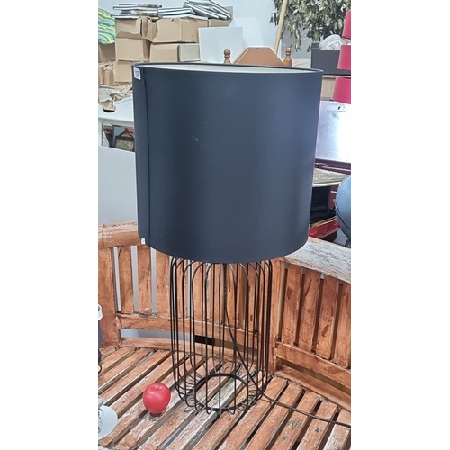 Modern black table lamp with a wireframe metal base and fabric drum ...