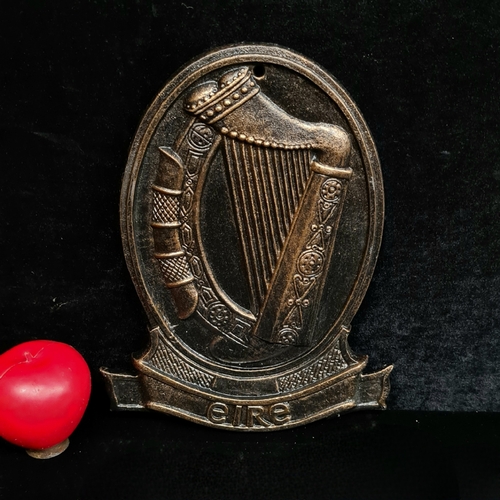 A cast iron wall plaque featuring the An Post Irish harp.