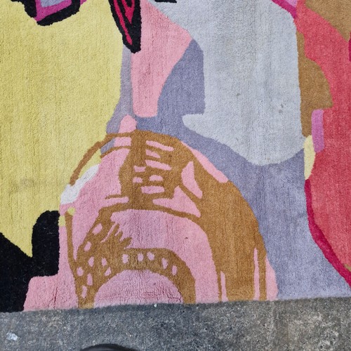 A vibrant modern rug featuring a bold abstract painterly composition ...