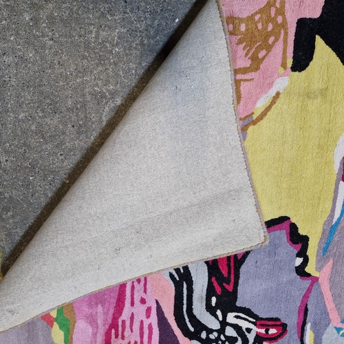 A vibrant modern rug featuring a bold abstract painterly composition ...