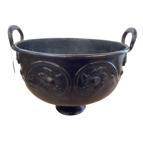 A large bronze and embossed two handled bowl, on raised circular plinth ...