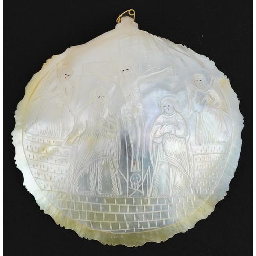 Mother of pearl shell carved with Christ on the cross, 12cm wide