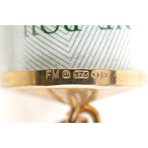 A 9ct gold mounted emergency one pound note charm, 2.6cm high, 2.6g.