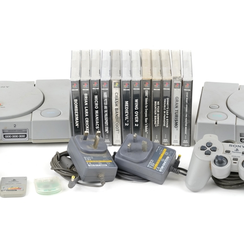 Four PlayStation 1 games consoles with three controllers and a ...