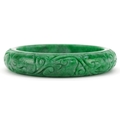 A Chinese green stone bangle with floral engraved decoration, 7cm in ...