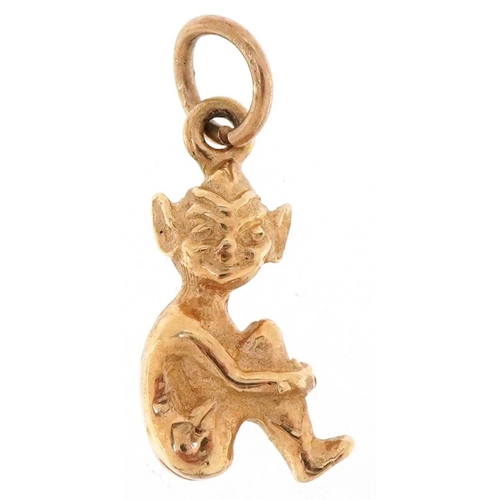 A 9ct gold charm in the form of a seated imp, 1.7cm high, 2.4g.