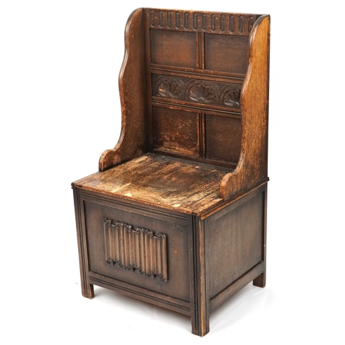A late 20th century oak box seat settle with linenfold decoration ...