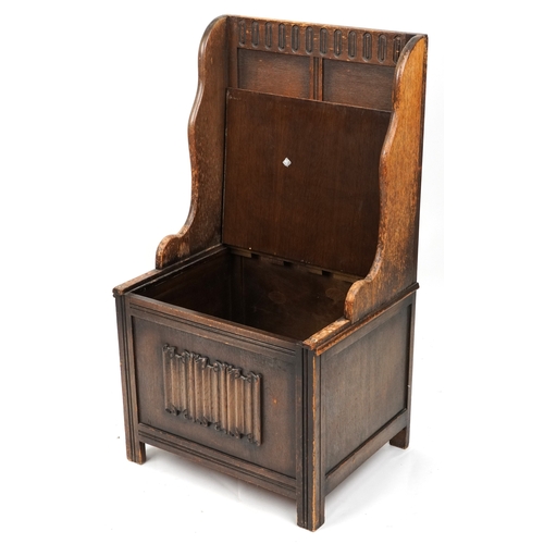 A late 20th century oak box seat settle with linenfold decoration ...