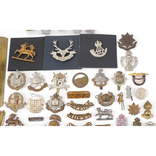 A collection of military interest cap badges and uniform buttons ...