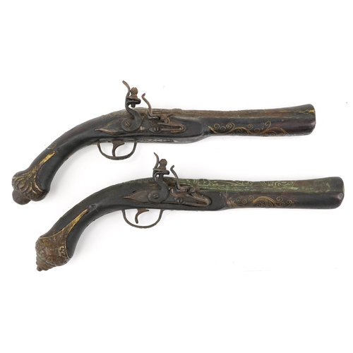 A pair of decorative flintlock pistol models with brass mounts, 38cm in ...