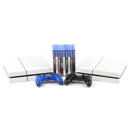 Two PlayStation 4 games consoles with two controllers and a selection ...