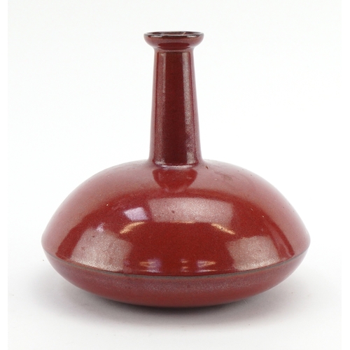 A Chinese porcelain bottleneck squatted vase having a red glaze, 18cm high.