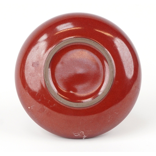 A Chinese porcelain bottleneck squatted vase having a red glaze, 18cm high.