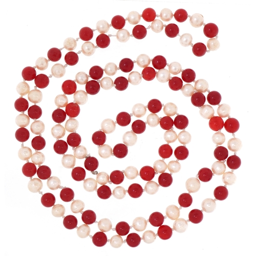 A Chinese red stone and freshwater pearl necklace, each bead 8.5mm in ...