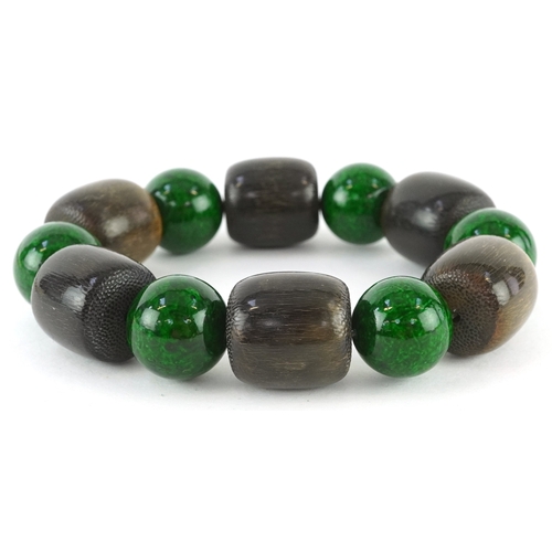 A Chinese green stone and horn bead bracelet, the largest beads ...