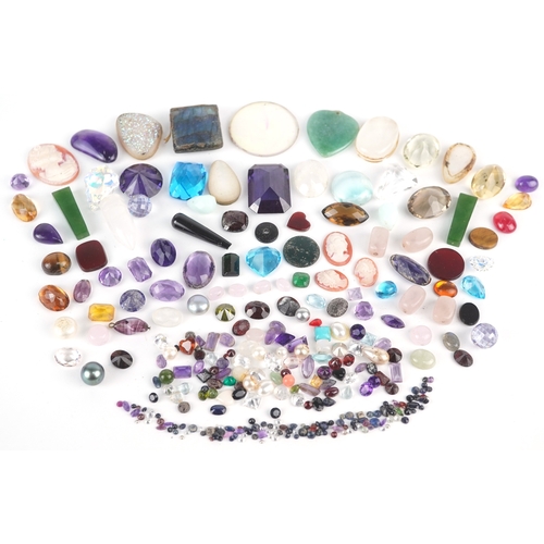 A collection of loose gemstones including sapphires, amethyst, smoky ...