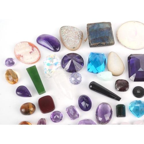 A collection of loose gemstones including sapphires, amethyst, smoky ...