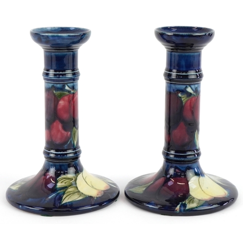 A pair of Moorcroft pottery candlesticks hand painted in the Wisteria ...