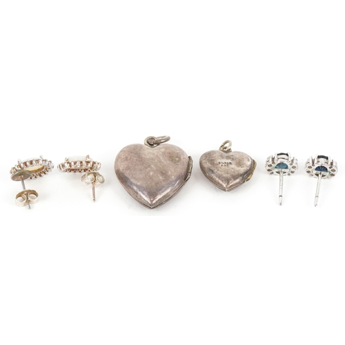 Two silver love heart pendants together with two pairs of white metal stud earrings, the largest 2.5
