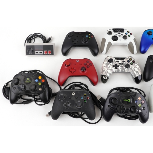 A selection of games console controllers, predominantly Xbox, together ...