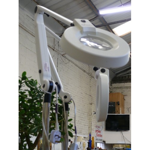 A LARGE FLOOR STANDING MAGNIFYING WORK LIGHT WITH WHEELED BASE