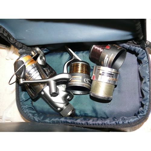 3 float fishing reels with extra spools in a reel bag
