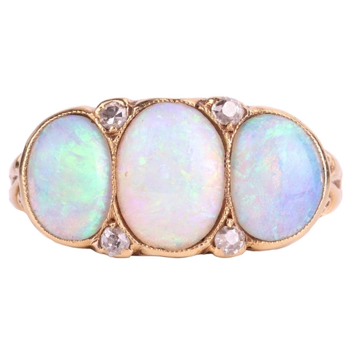 An opal and diamond-set three stone ring, the oval cabochon opals are ...