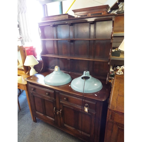 An Ercol dark wood dresser the top having two plate racks above two ...