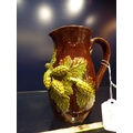 A Rye Pottery brown glazed milk jug with applied hops and vine marks to ...