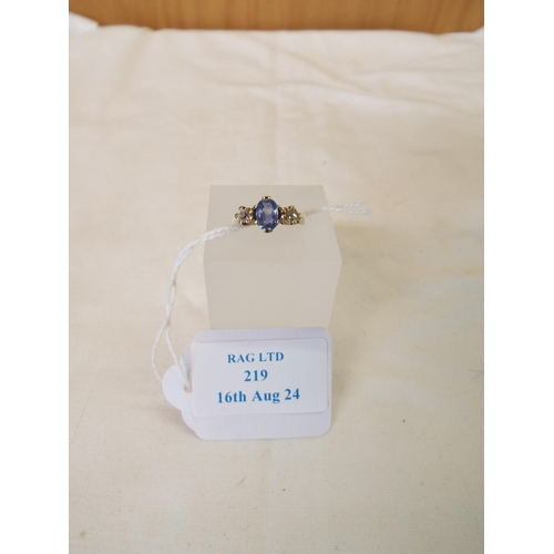 A 9ct gold ring inset with central sapphire flanked by diamonds, size K