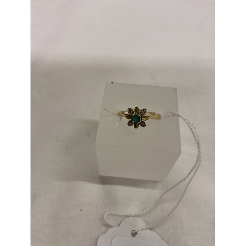 An 18ct gold floral ring inset with emerald flanked by diamonds, size L