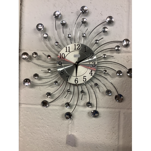 A modern metal and jewelled swirl wall clock