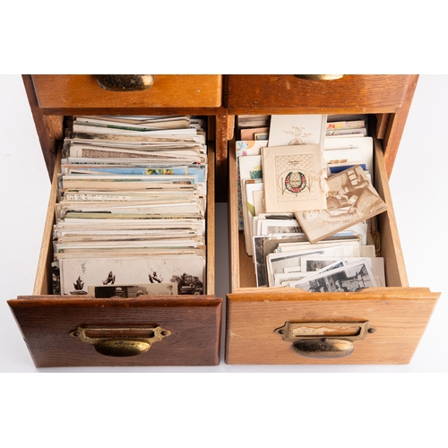 A wooden four drawer cabinet full of old postcards, greetings cars ...