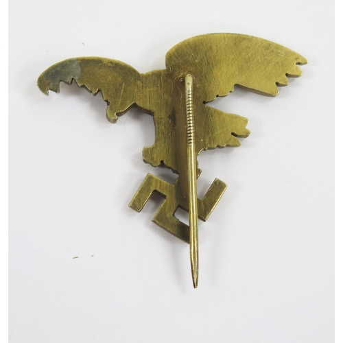 A World War II gilt brass Luftwaffe stick pin, of an eagle holding a ...