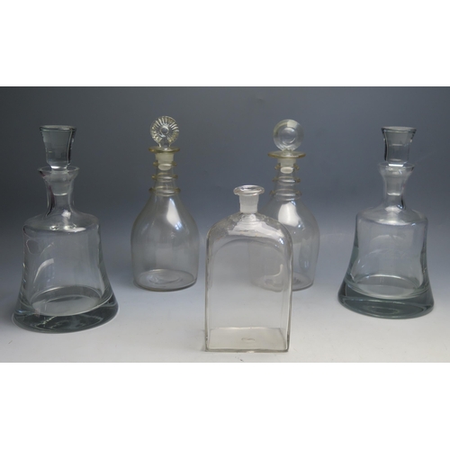 A pair of clear glass mallet-shaped decanters and three other decanters ...