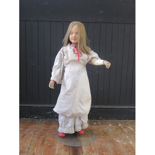 A shop manikin of a young girl, mounted on a circular base, 109cm high.