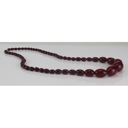 An amberoid graduated bead necklace, largest bead c. 29x21mm bead, 80cm ...