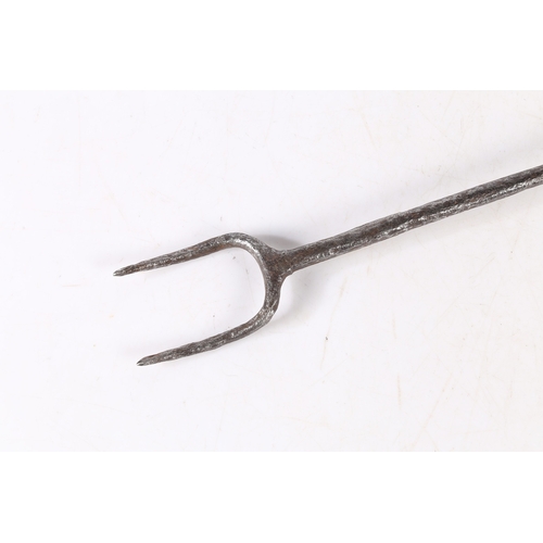 A MID-18TH CENTURY IRON AND BRASS MEAT FORK, ENGLISH, CIRCA 1750. With two tines, the stem flattenin