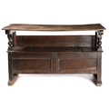 A MID-17TH CENTURY OAK TABLE-SETTLE, CIRCA 1650. Having a pivotal ...
