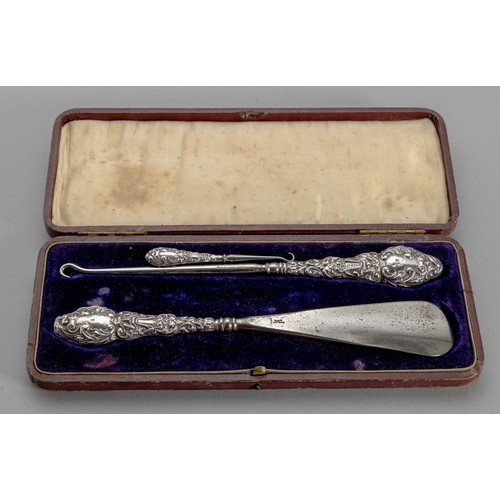 A CASED SET OF EDWARD VII SILVER BUTTON HOOKS AND A SILVER SHOE HORN, H ...