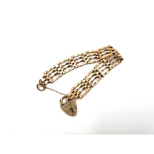 A 9ct yellow gold four bar gate bracelet with safety chain and padlock ...