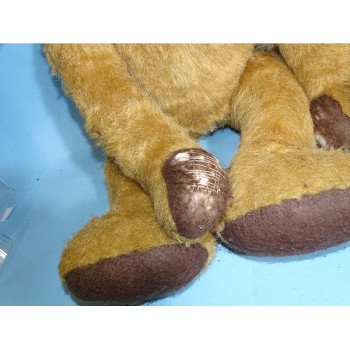 A large nylon plush-covered teddy bear with stitched nose, pronounced ...