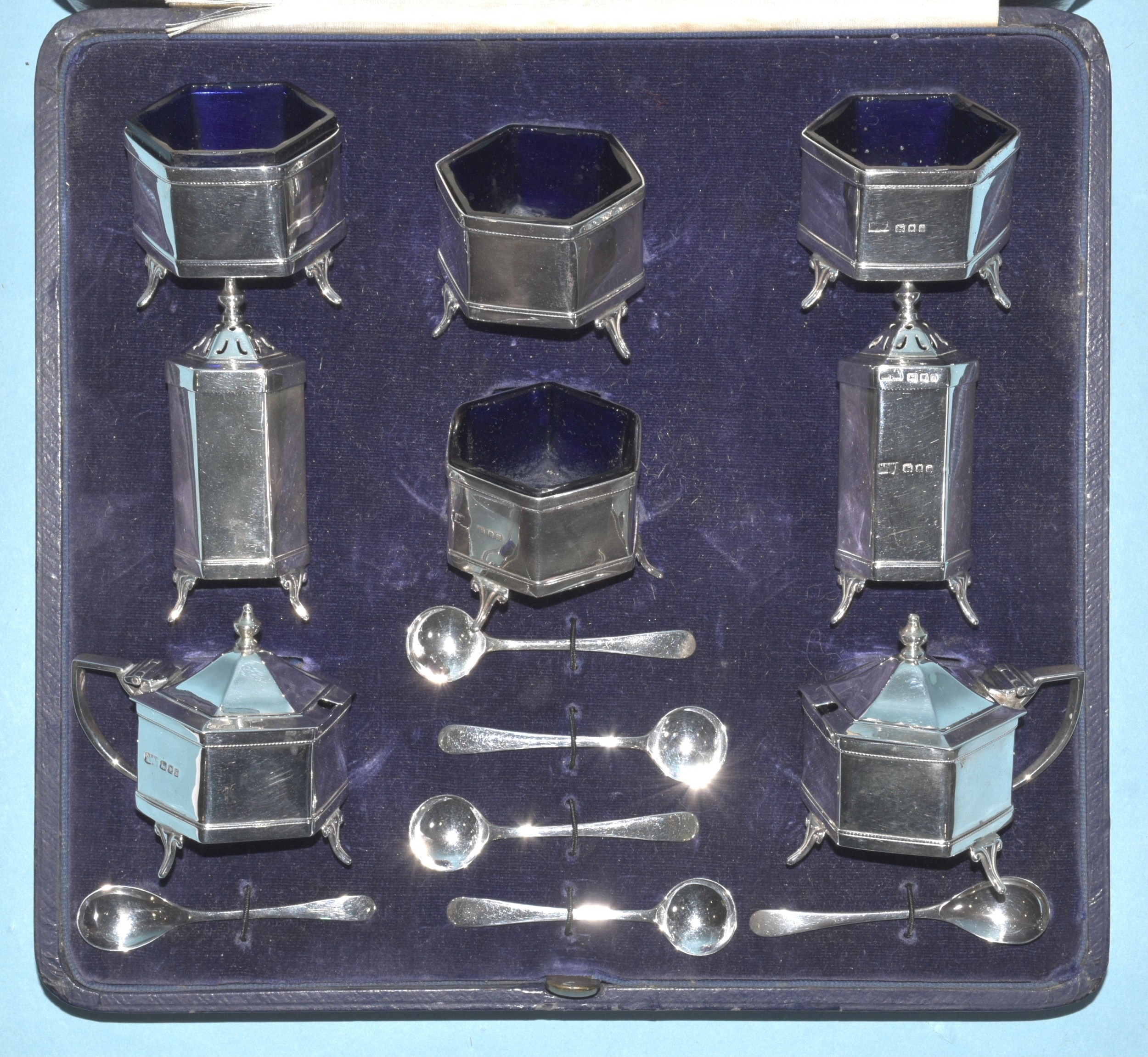 A cased silver double cruet set of plain hexagonal form, London 1924, with blue glass liners, 253g,