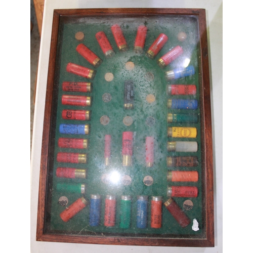 Shop display case containing collection of shotgun cartridges. To ...